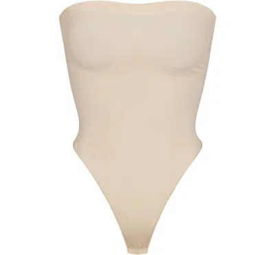 Skims Seamless Sculpt Strapless Thong Bodysuit In Sand In Beige | ModeSens
